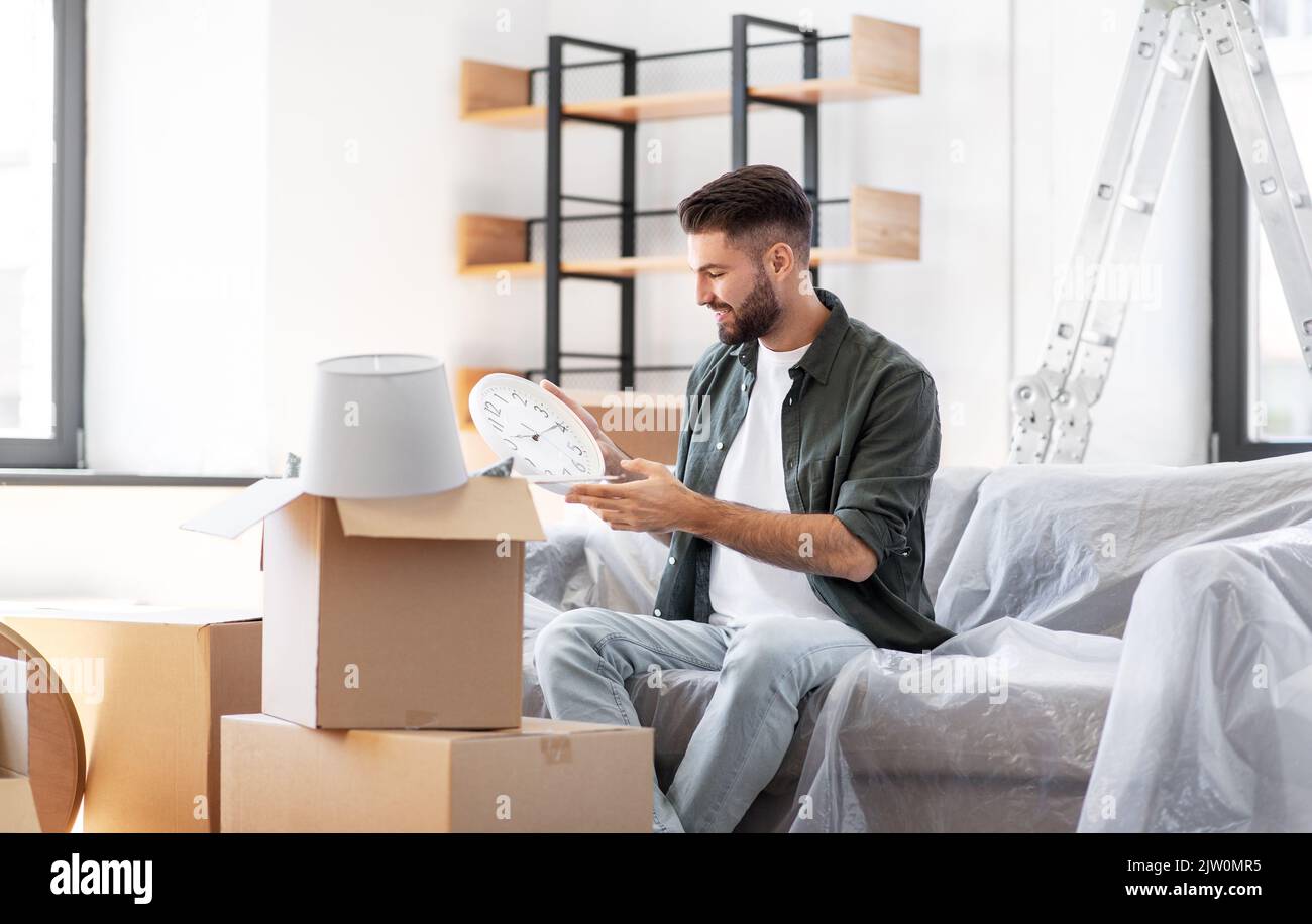 happy man unpacking boxes and moving to new home Stock Photo - Alamy