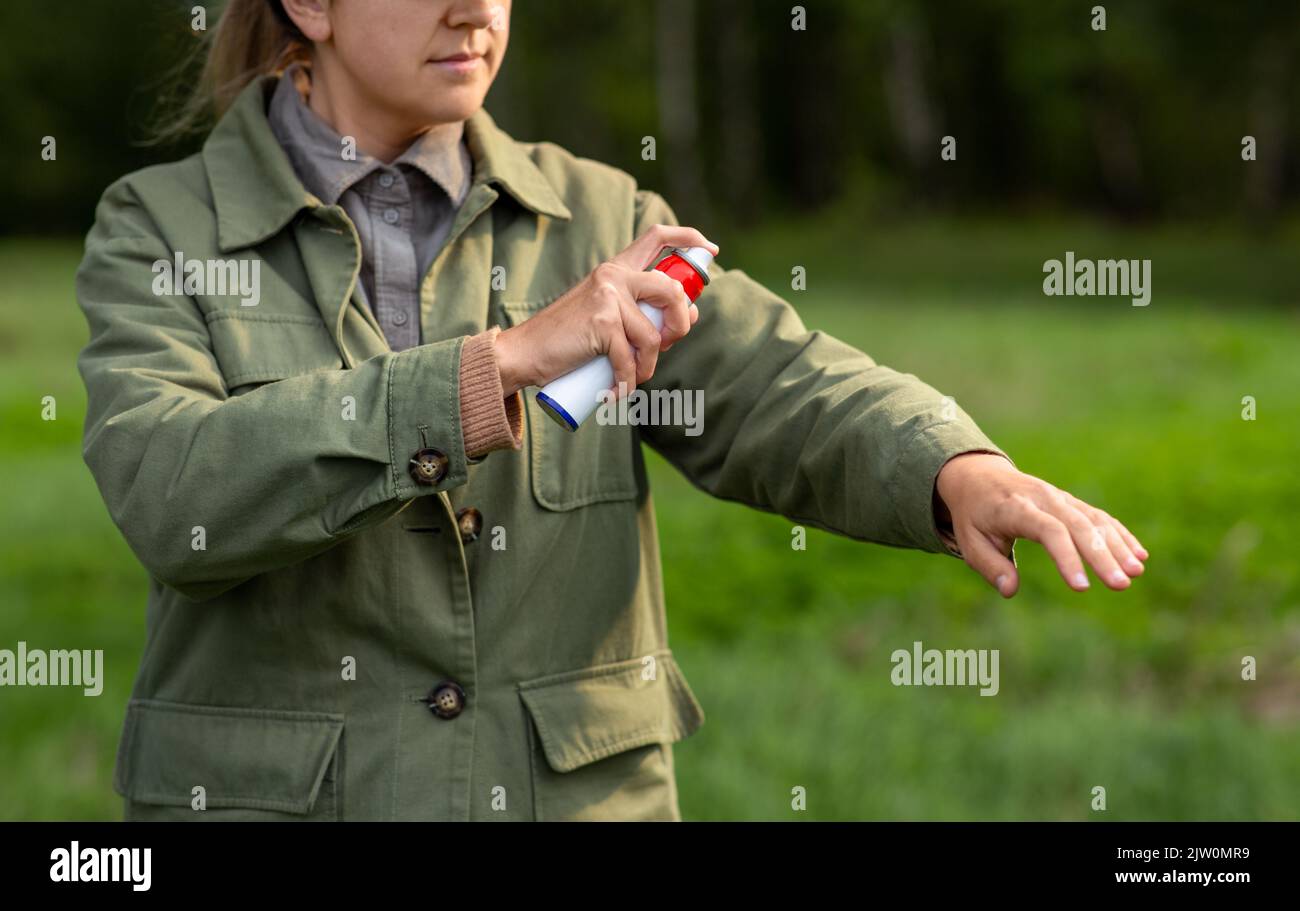 woman spraying insect repellent to hand at park Stock Photo - Alamy