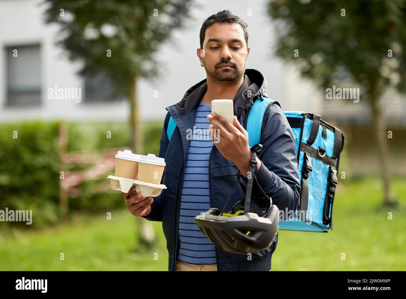 food delivery man with takeaway coffee and phone Stock Photo - Alamy