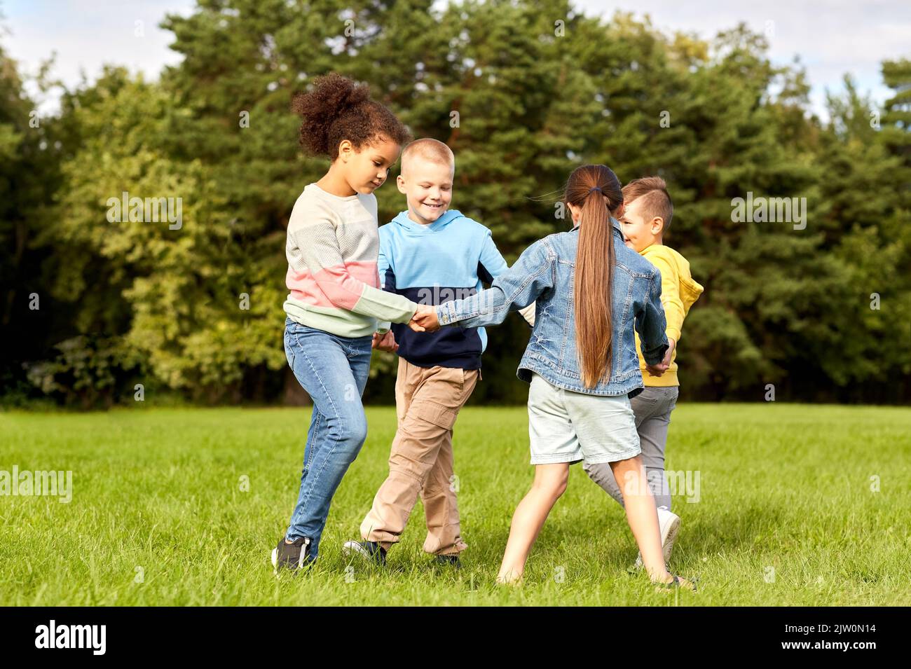 happy children playing round dance at park Stock Photo - Alamy