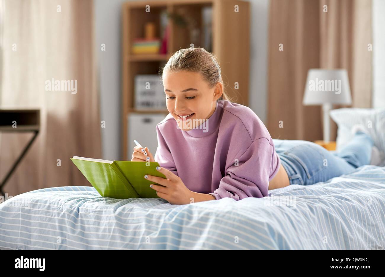 girl lying on bed and writing to diary at home Stock Photo - Alamy