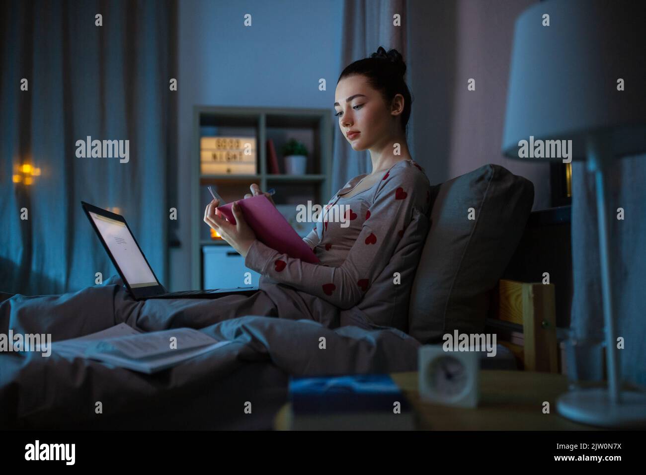 student girl with notebook and laptop at night Stock Photo - Alamy