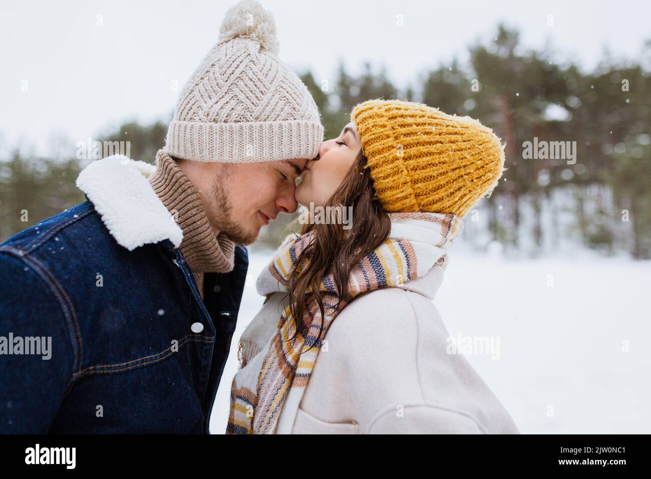 happy woman kissing man to forehead in winter Stock Photo - Alamy