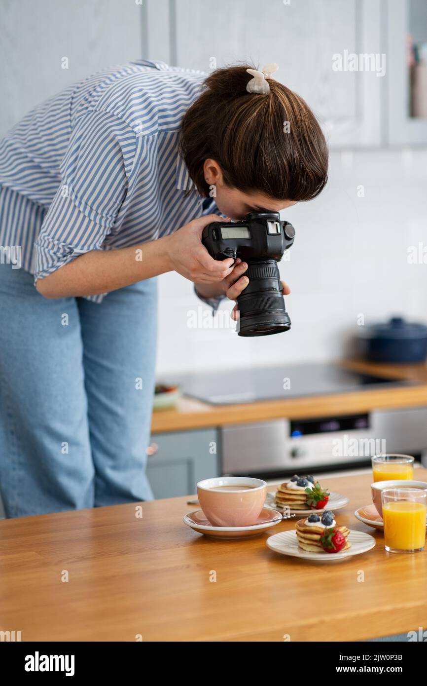 food photographer with camera working in kitchen Stock Photo - Alamy