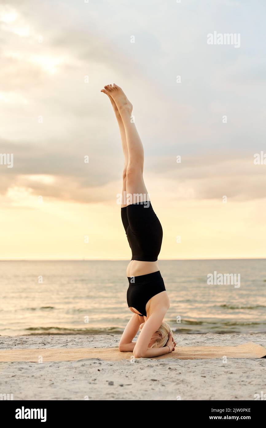 Woman doing headstand on beach hi-res stock photography and images - Alamy