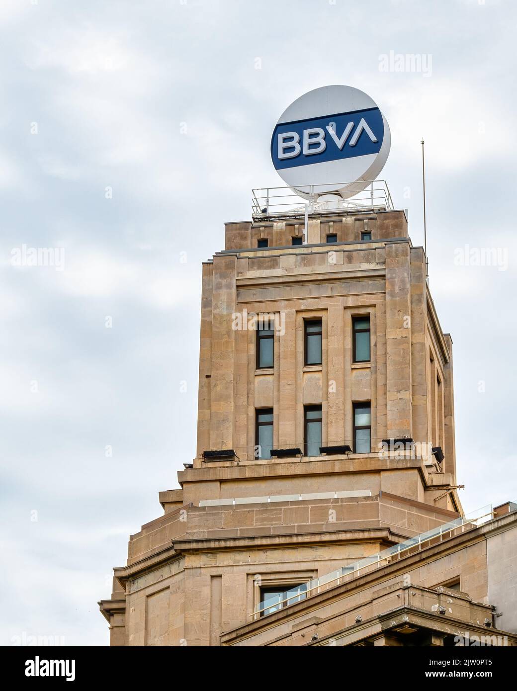Logo or sign of the BBVA Spanish bank on top of the rectangular tower ...