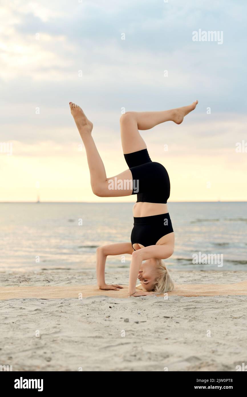 Woman doing headstand on beach hi-res stock photography and images - Alamy