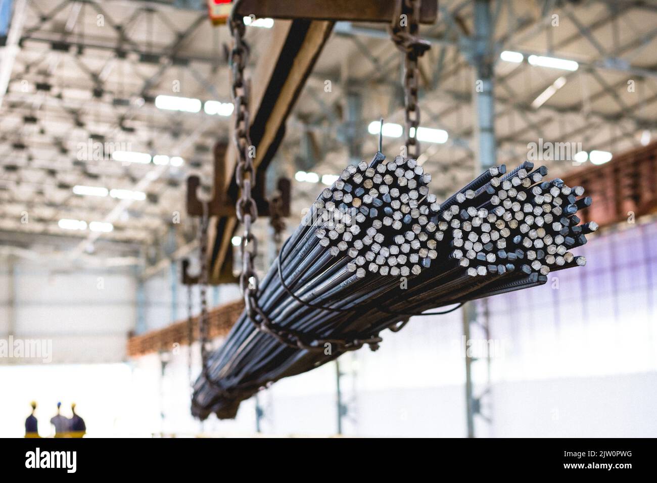 A pile of steel rods hanging on a metal structure at a manufacturing ...