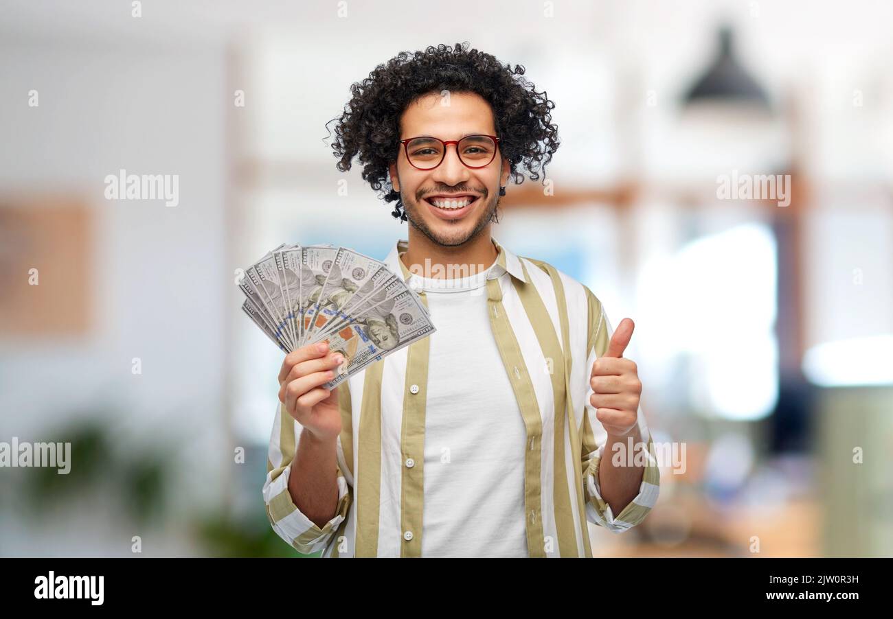 happy man with money showing thumbs up at office Stock Photo - Alamy