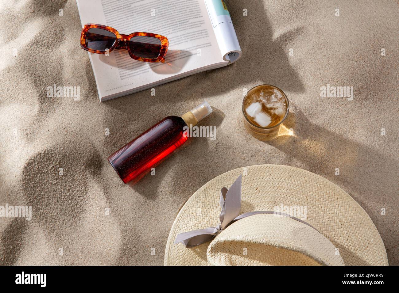 magazine, sunglasses and sunscreen on beach sand Stock Photo - Alamy