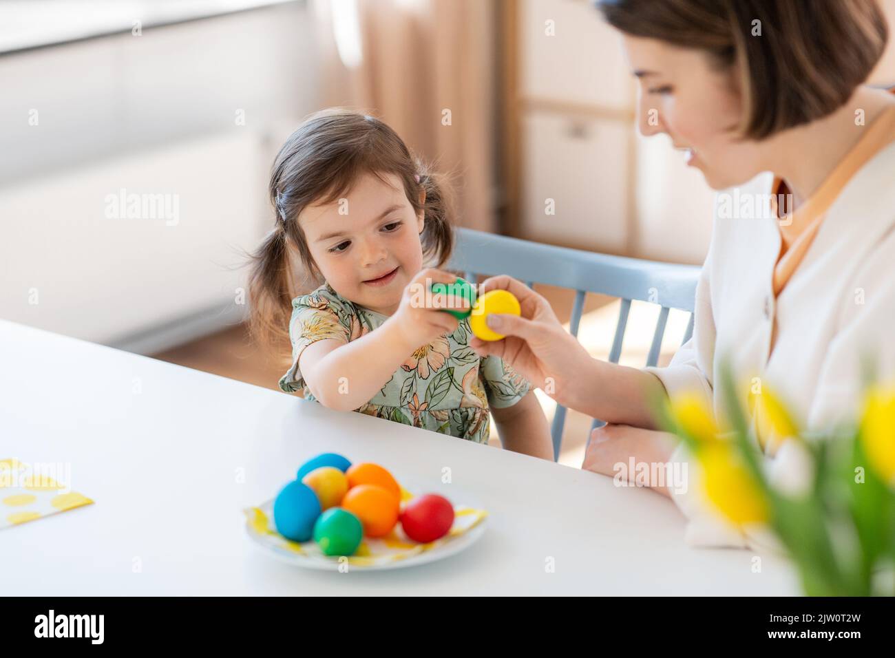 baby girl and mother tapping easter eggs at home Stock Photo - Alamy