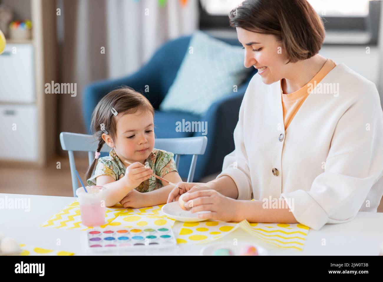 mother with child coloring easter eggs at home Stock Photo - Alamy