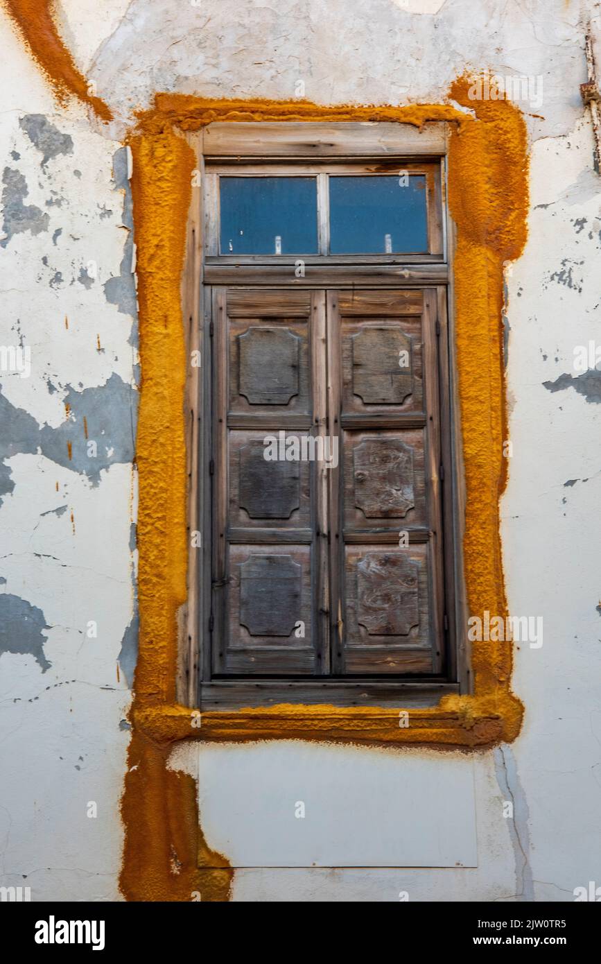 old rustic wooden shutter covering a window in a whitewashed wall on a ...