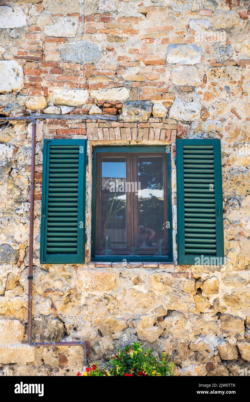 A window with green shutters on a Tuscany stone wall in the Chianti ...