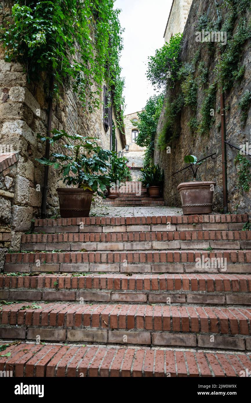 Looking up a series of old, weathered brick stairs between the stone ...