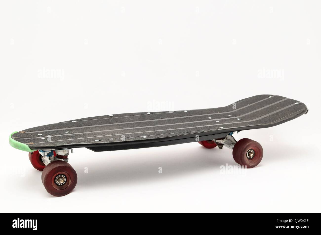 A single black skateboard with white stripes and red wheels in front of ...