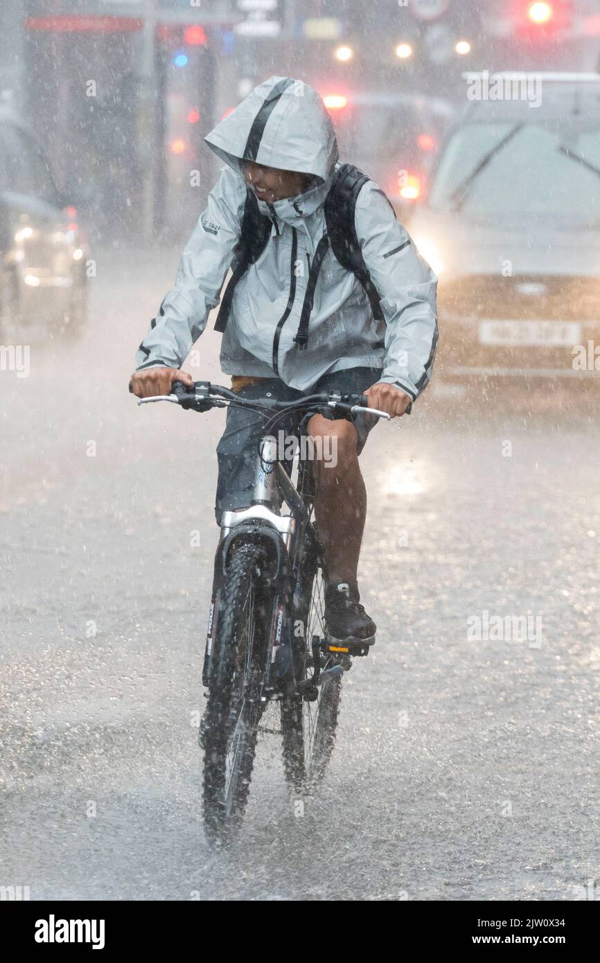 Amber rain catches Londoners this afternoon at Tower Bridge. Image shot ...