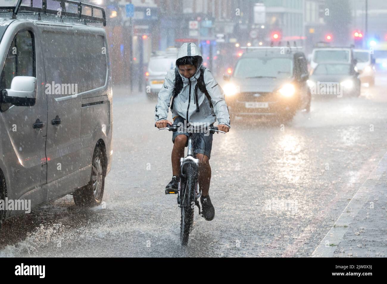 Amber rain catches Londoners this afternoon at Tower Bridge. Image shot ...