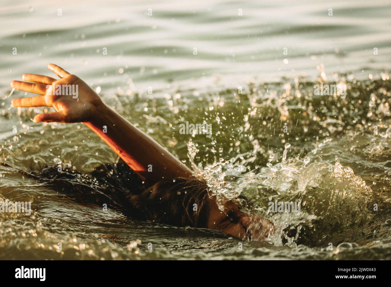 A man is drowning in water. A hand peeks out from under a water. A ...