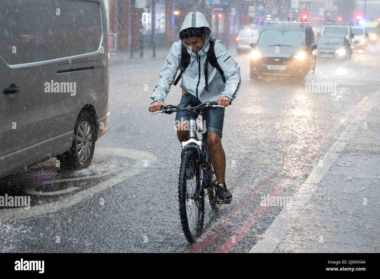 Amber rain catches Londoners this afternoon at Tower Bridge. Image shot ...