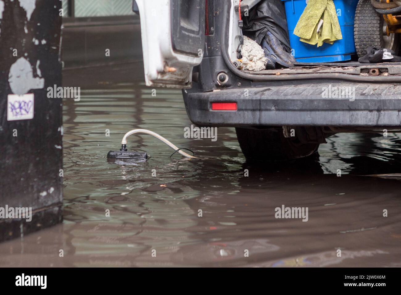 Workers clean up a flash flood near Euston following heavy amber rain ...