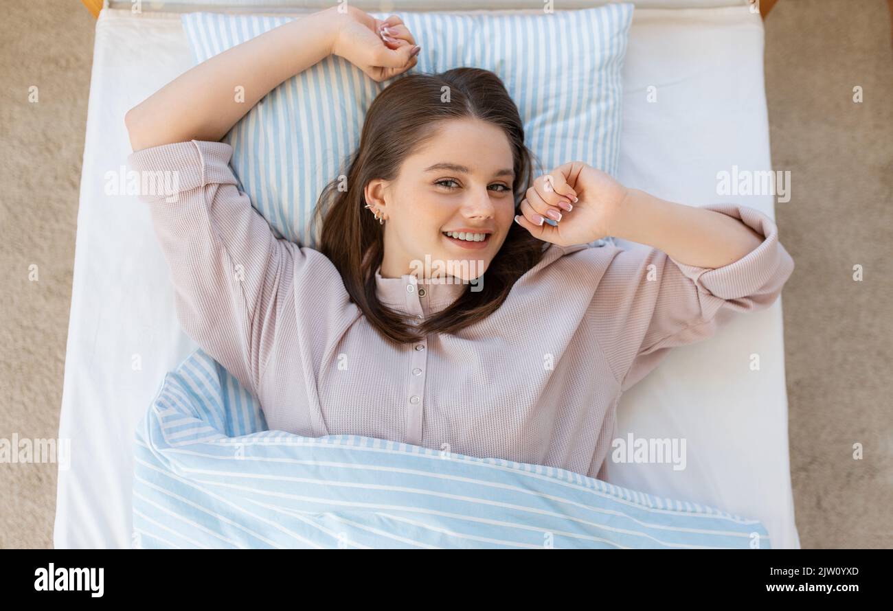 happy smiling girl stretching in bed Stock Photo - Alamy