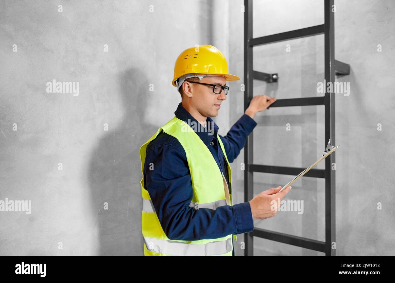 builder or worker with clipboard at ladder Stock Photo - Alamy