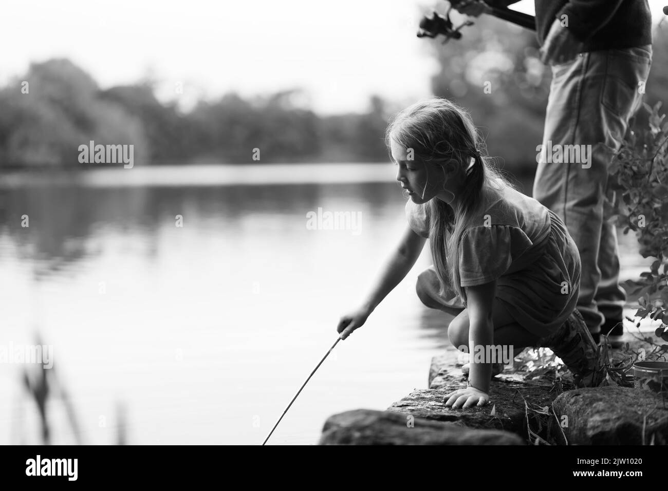 Young girl pushing her net in the water to try and catch something in ...