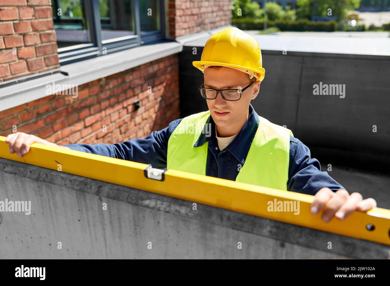 male builder with level measuring wall Stock Photo - Alamy