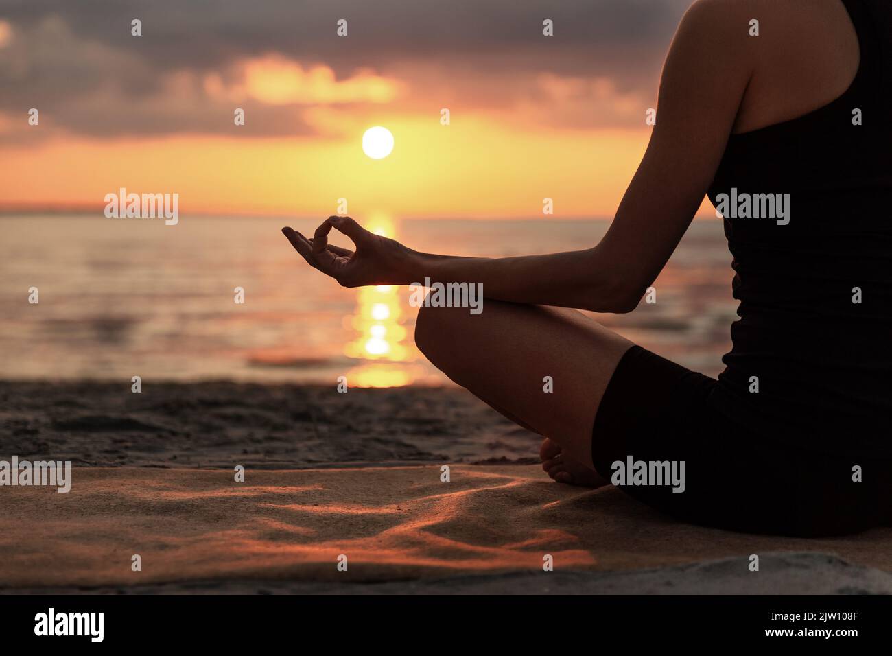 woman meditating in lotus pose on beach Stock Photo - Alamy