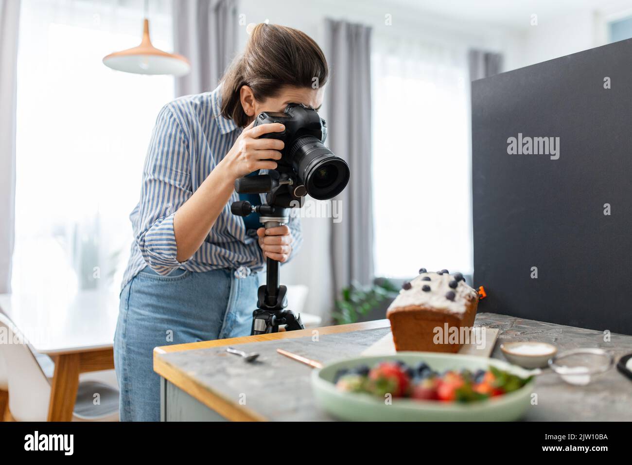 food photographer with camera working in kitchen Stock Photo - Alamy