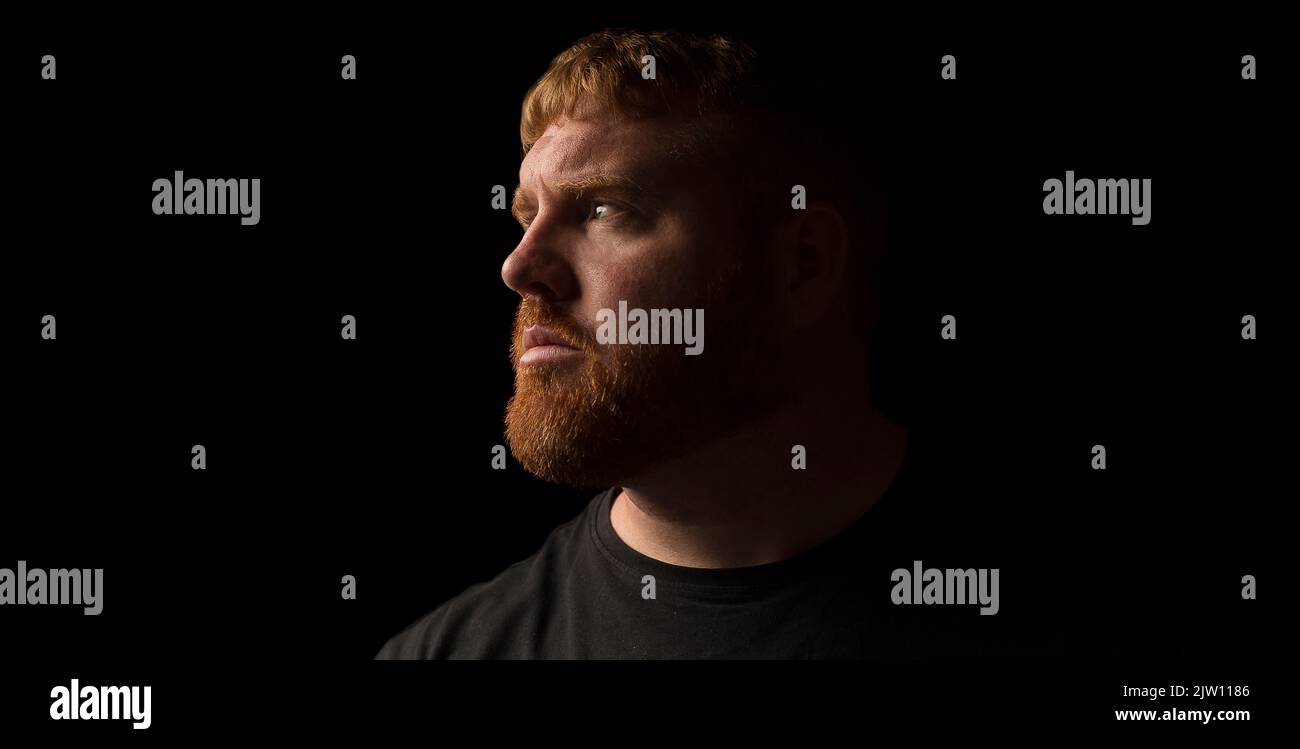Adult Caucasian male with beard looking sideways in a moody shot Stock ...