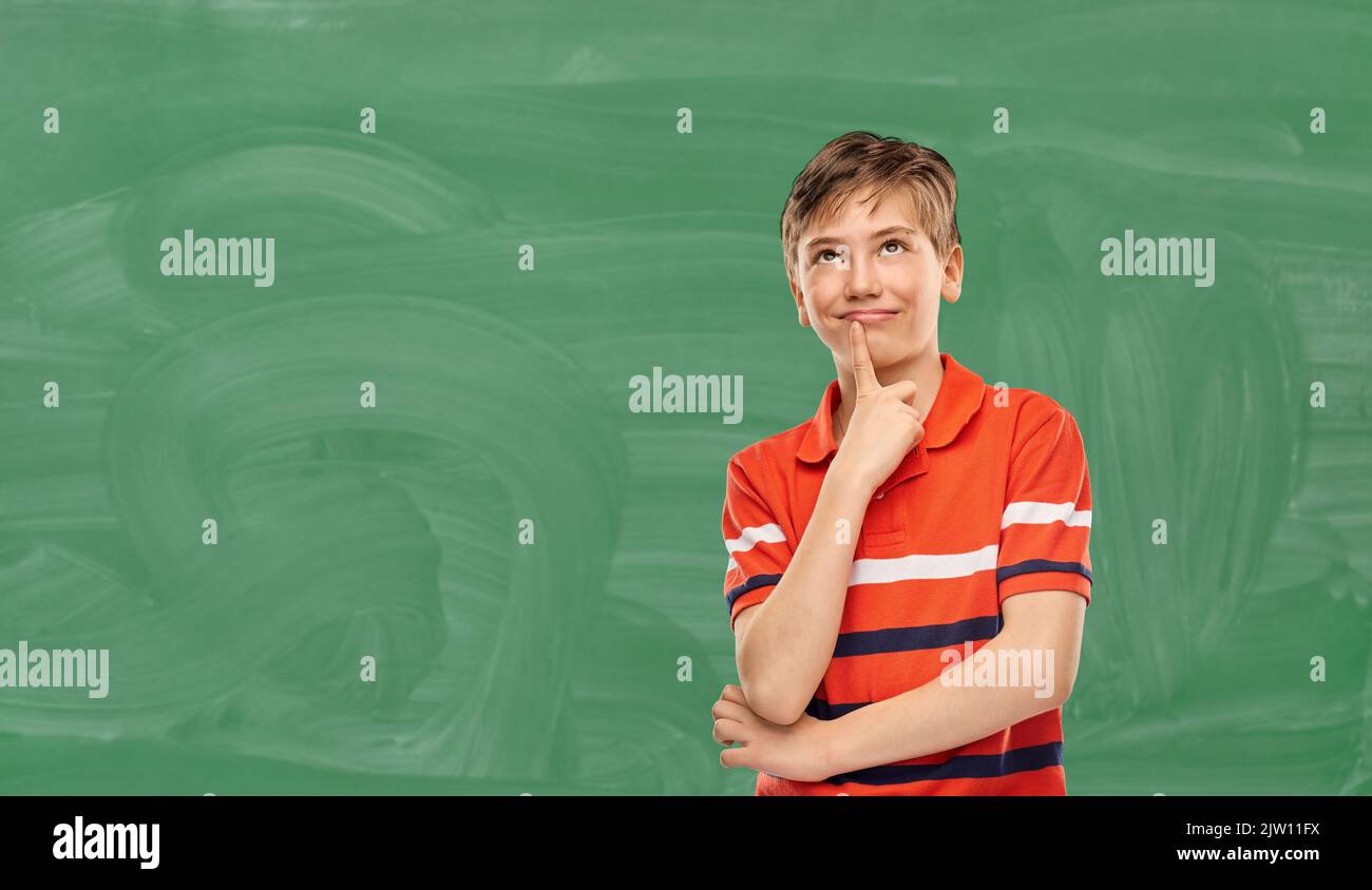 happy thinking student boy over green chalkboard Stock Photo - Alamy