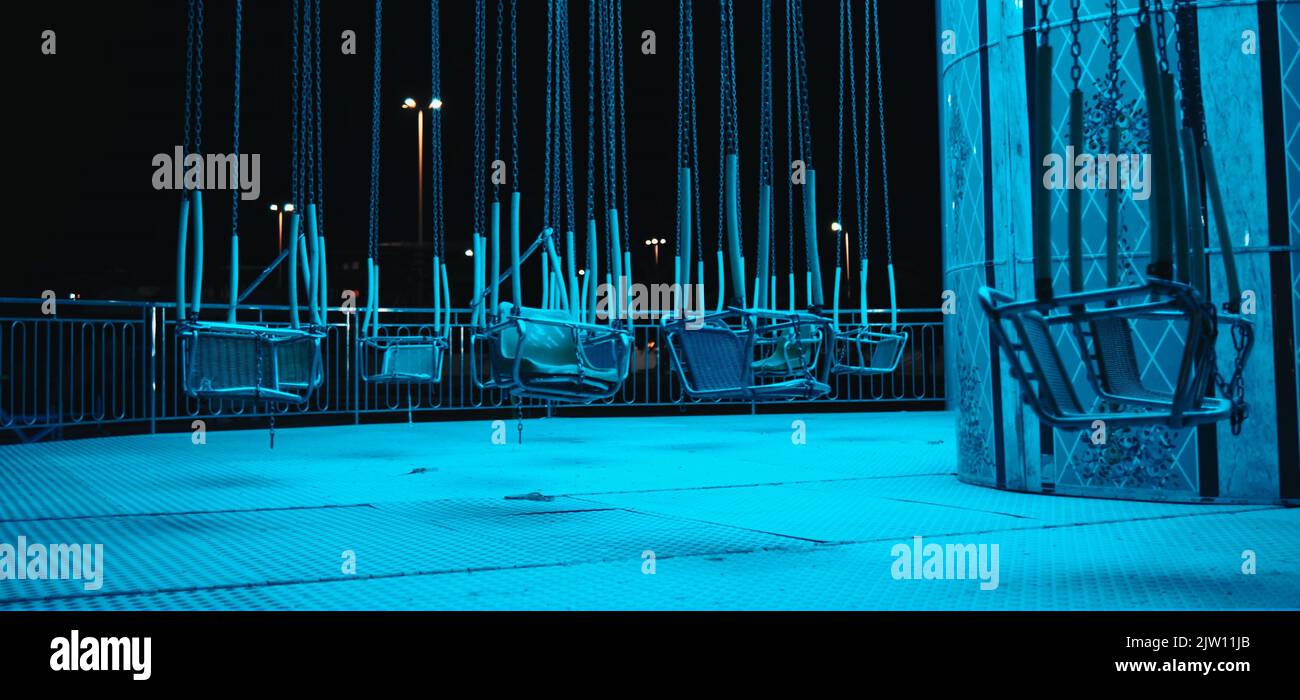 Empty seats in a carnival ride at night Stock Photo - Alamy