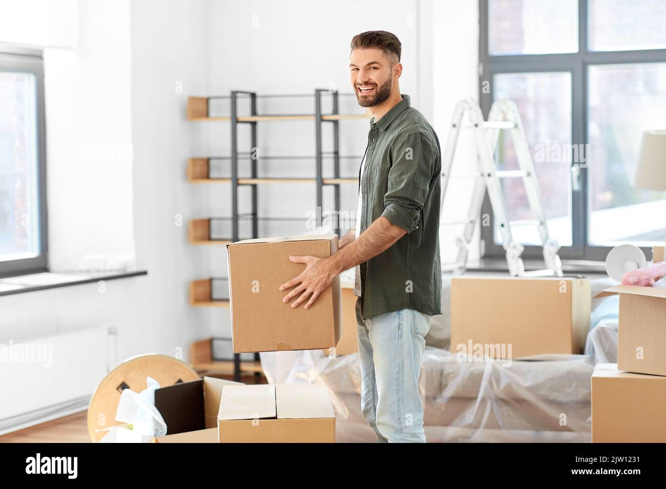 happy man with box moving to new home Stock Photo - Alamy