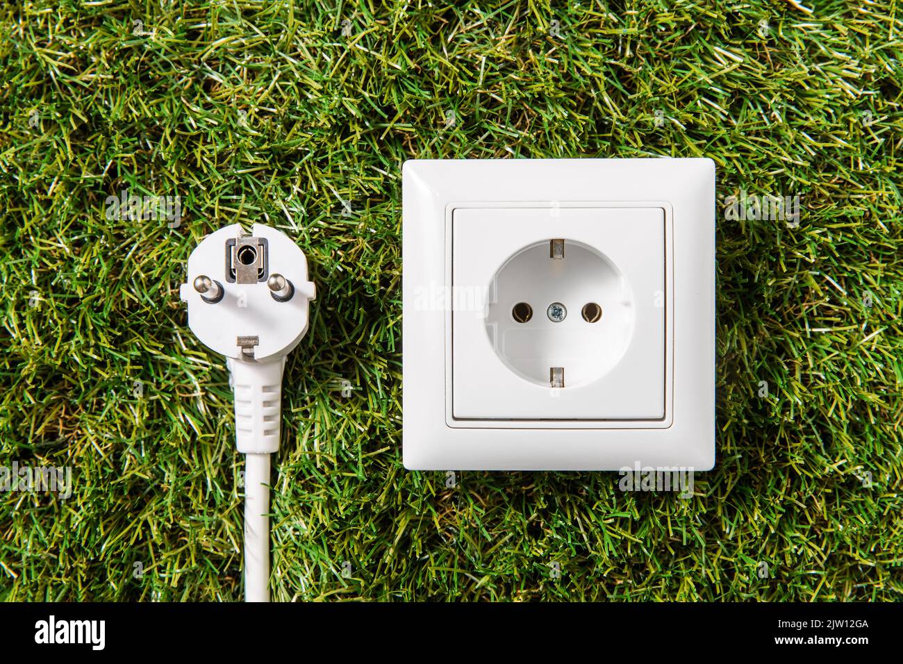 close up of socket and plug on green grass Stock Photo - Alamy