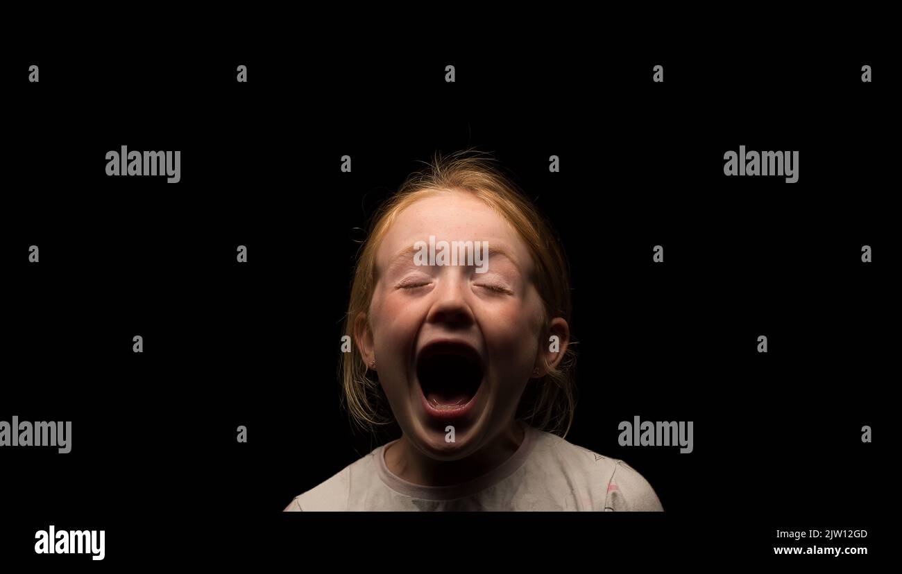 Young Caucasian female with a screaming expression on her face and her ...