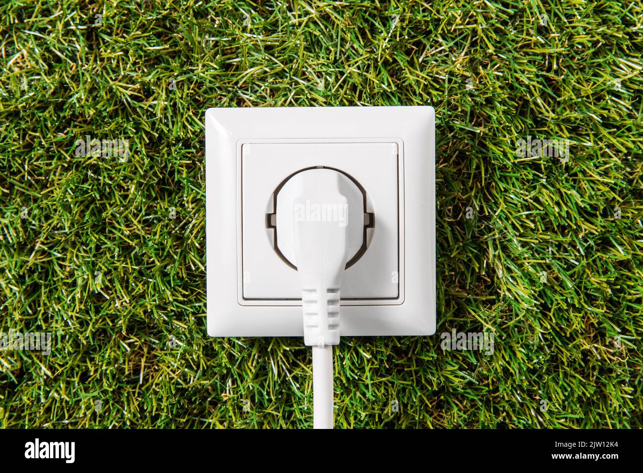 Green socket with power plug and cable on green grass hi-res stock ...