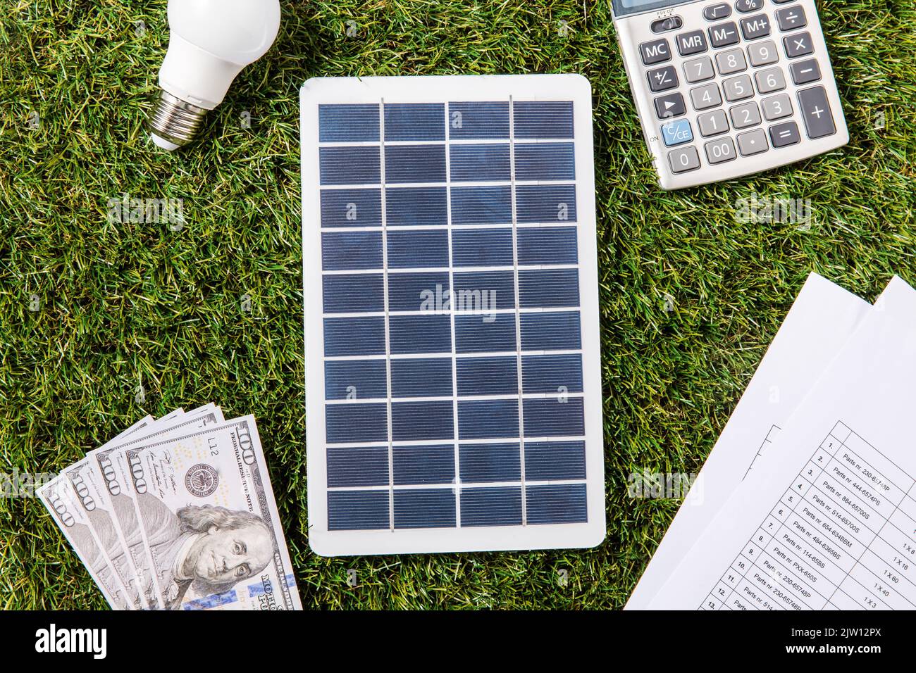solar battery, bulb, money, bills and calculator Stock Photo - Alamy