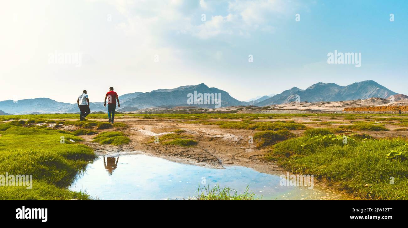 Two men hiking in a valley Stock Photo - Alamy