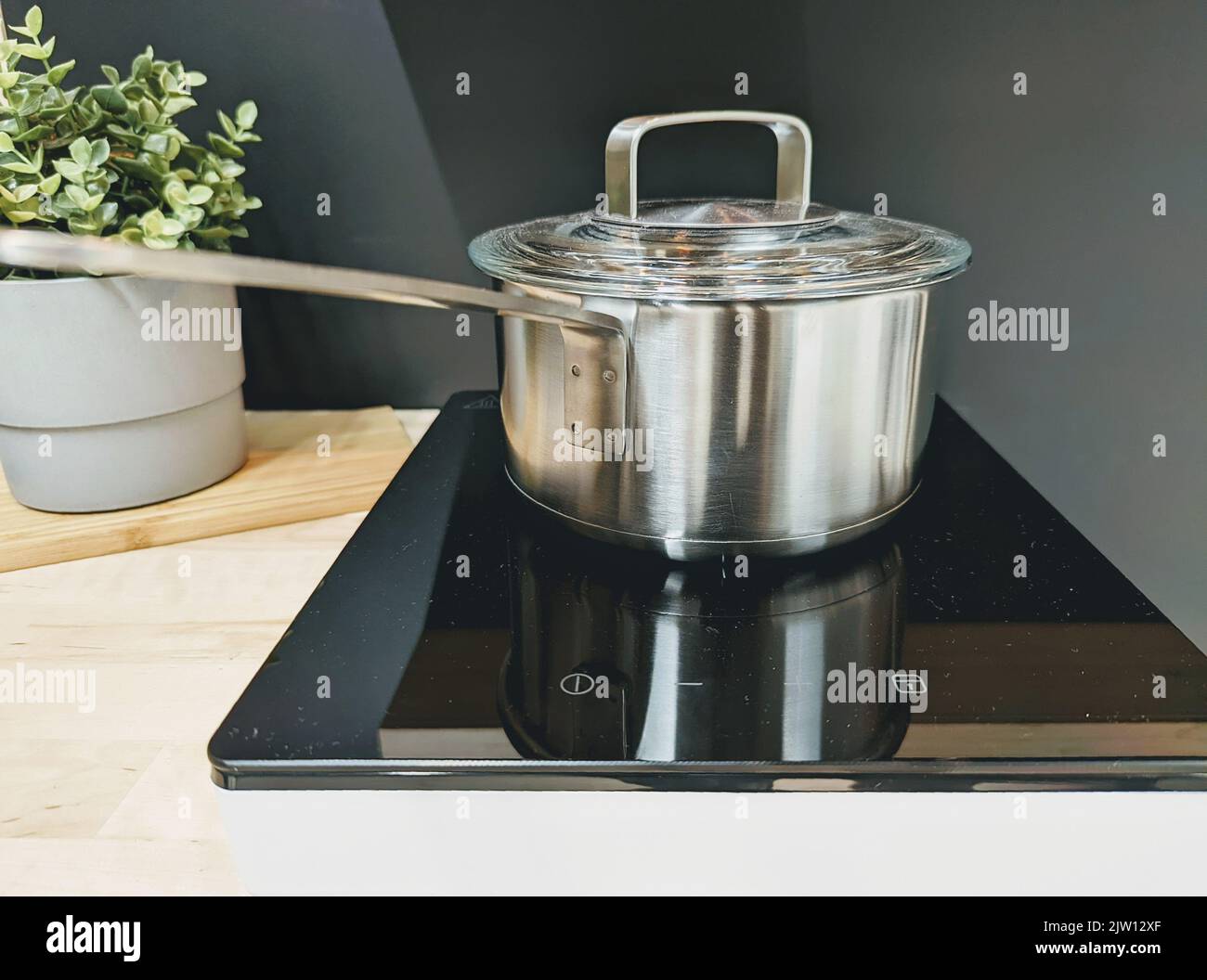 A shiny silver pot with closed lid on the stove Stock Photo - Alamy