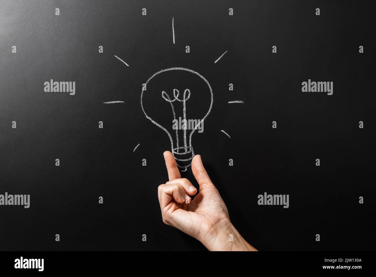 close up of hand holding lightbulb chalk drawing Stock Photo - Alamy