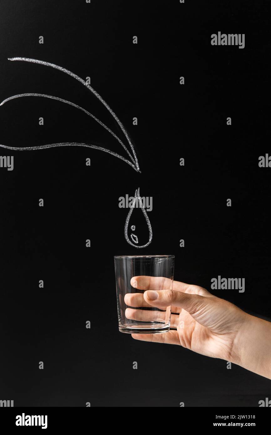 close up of hand with glass and water drop drawing Stock Photo - Alamy