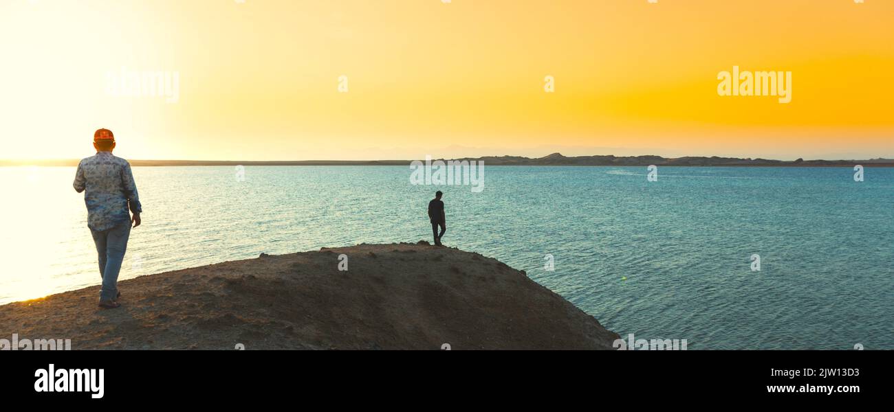 Two men walking to the edge of sea Stock Photo - Alamy