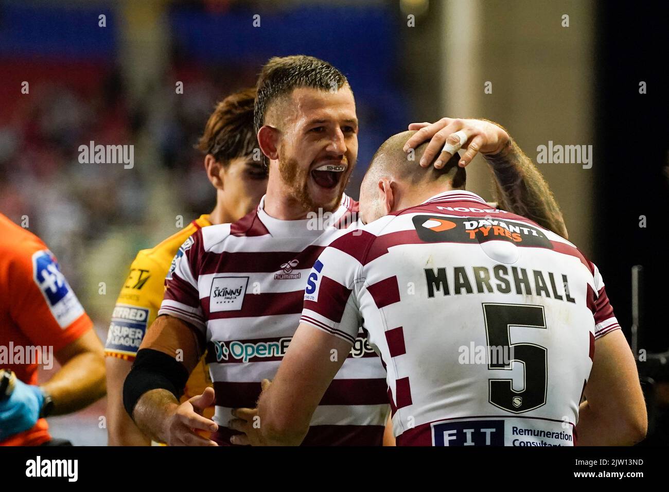 Cade Cust #6 of Wigan Warriors celebrates with try scorer Liam Marshall ...