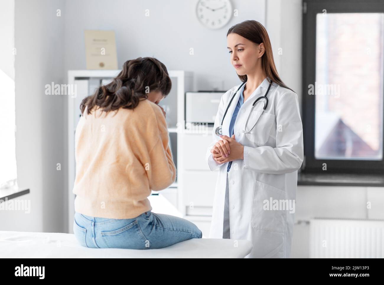 female doctor talking to sad woman at hospital Stock Photo - Alamy