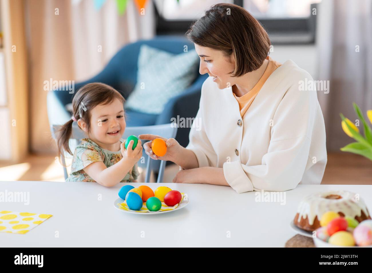 baby girl and mother tapping easter eggs at home Stock Photo - Alamy