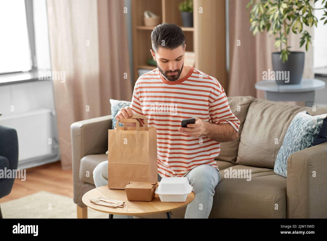 man with phone checking food order at home Stock Photo - Alamy