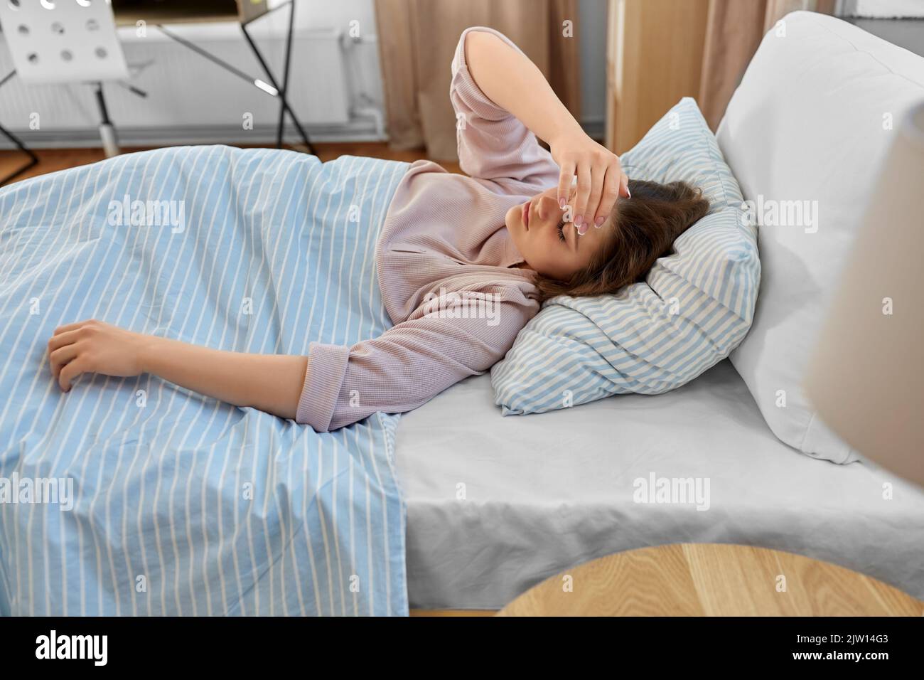 sleepy girl lying in bed at home in morning Stock Photo - Alamy