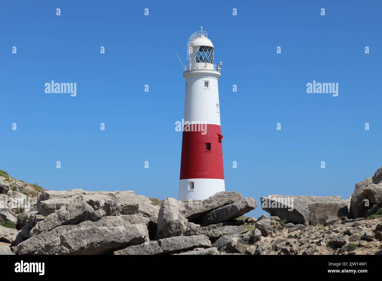 The distinctive red and white striped lighthouse at Portland Bill in ...